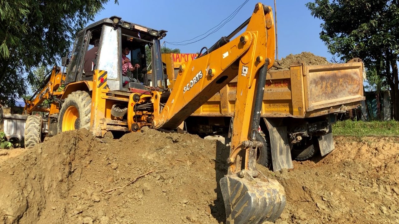 Loading Soil In Tripper Dump Escorts Backhoe Loader Video - YouTube