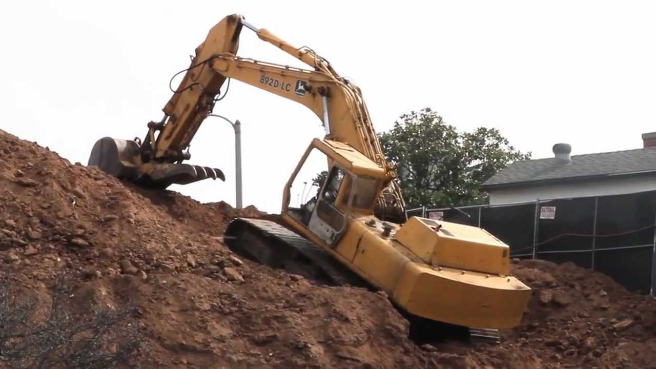 John Deer excavator digging on a hIll - YouTube
