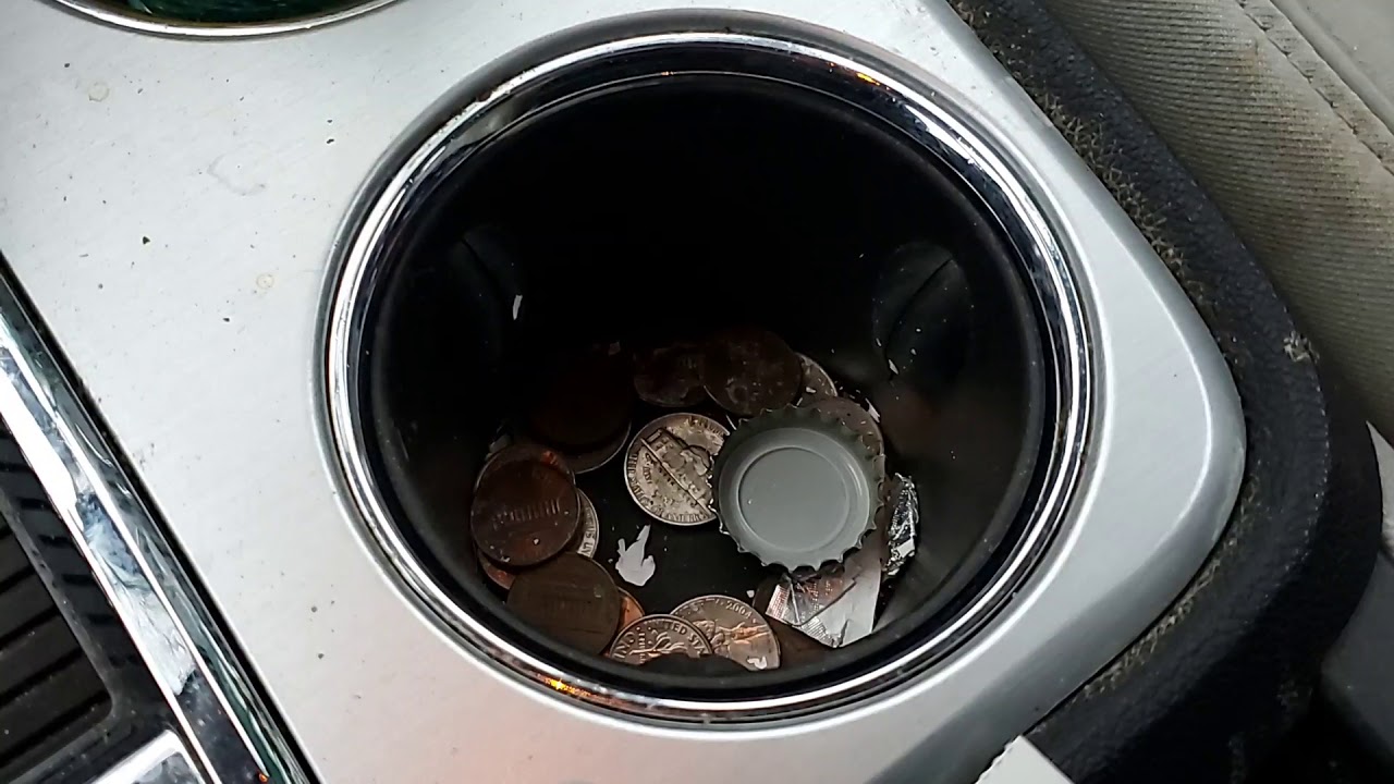 Spare change and a bottle cap in a cup holder. - YouTube