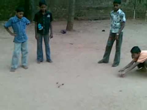 indian boys playing goli (famous in kanyakumari) koli viliyaduthal ...
