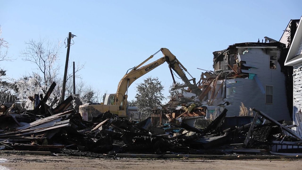 Heavy equipment demolishes remaining fire-damaged buildings - YouTube