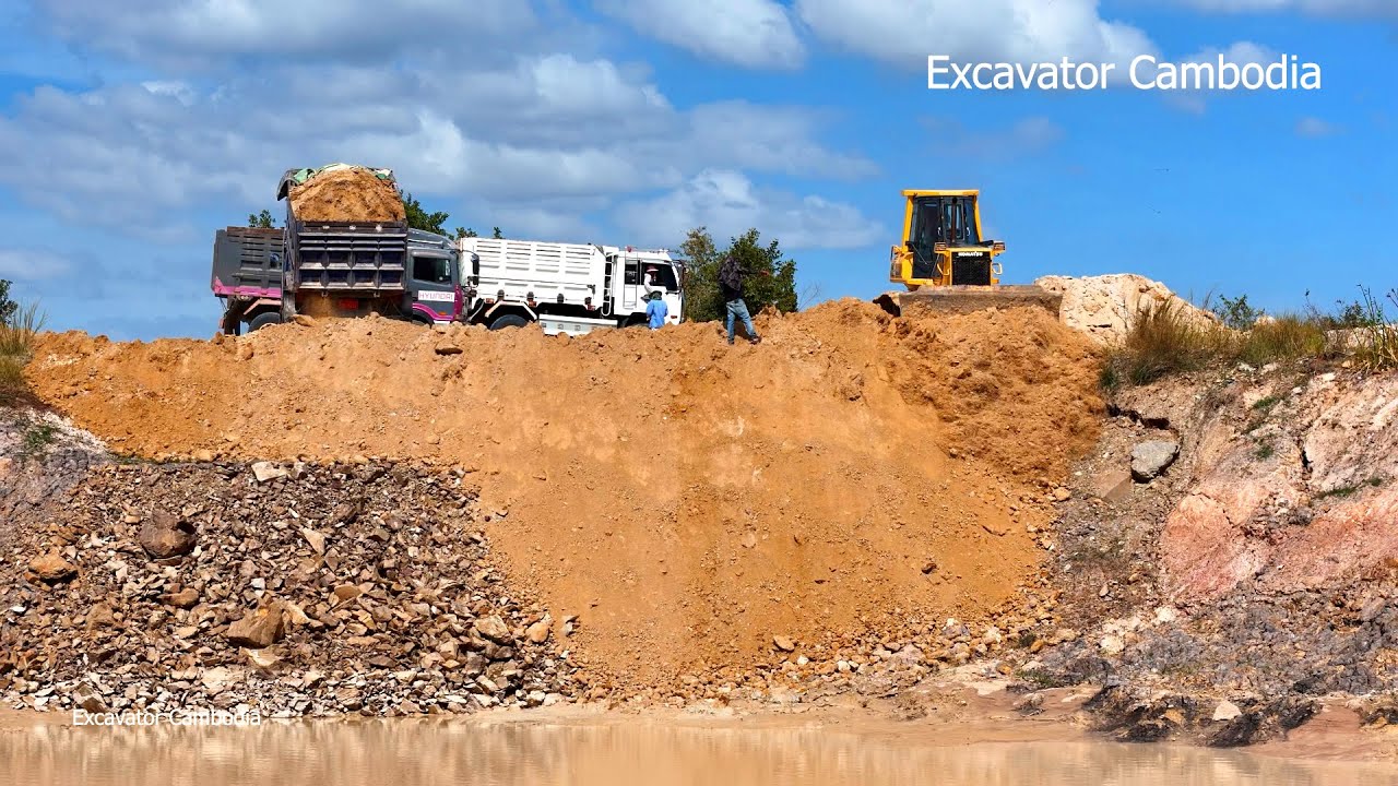 Bulldozer Pushing Dirt To Slope Filling Pond And Dump Truck Dumping ...