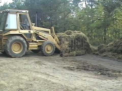 CAT 416 Backhoe Pushing Off Load of Wisconsin Long Fiber Moss - YouTube