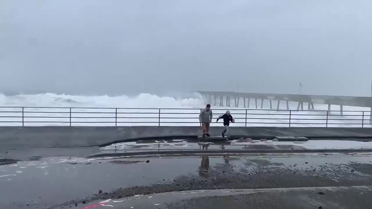 Storm causes rough waves to knock over pedestrians - YouTube