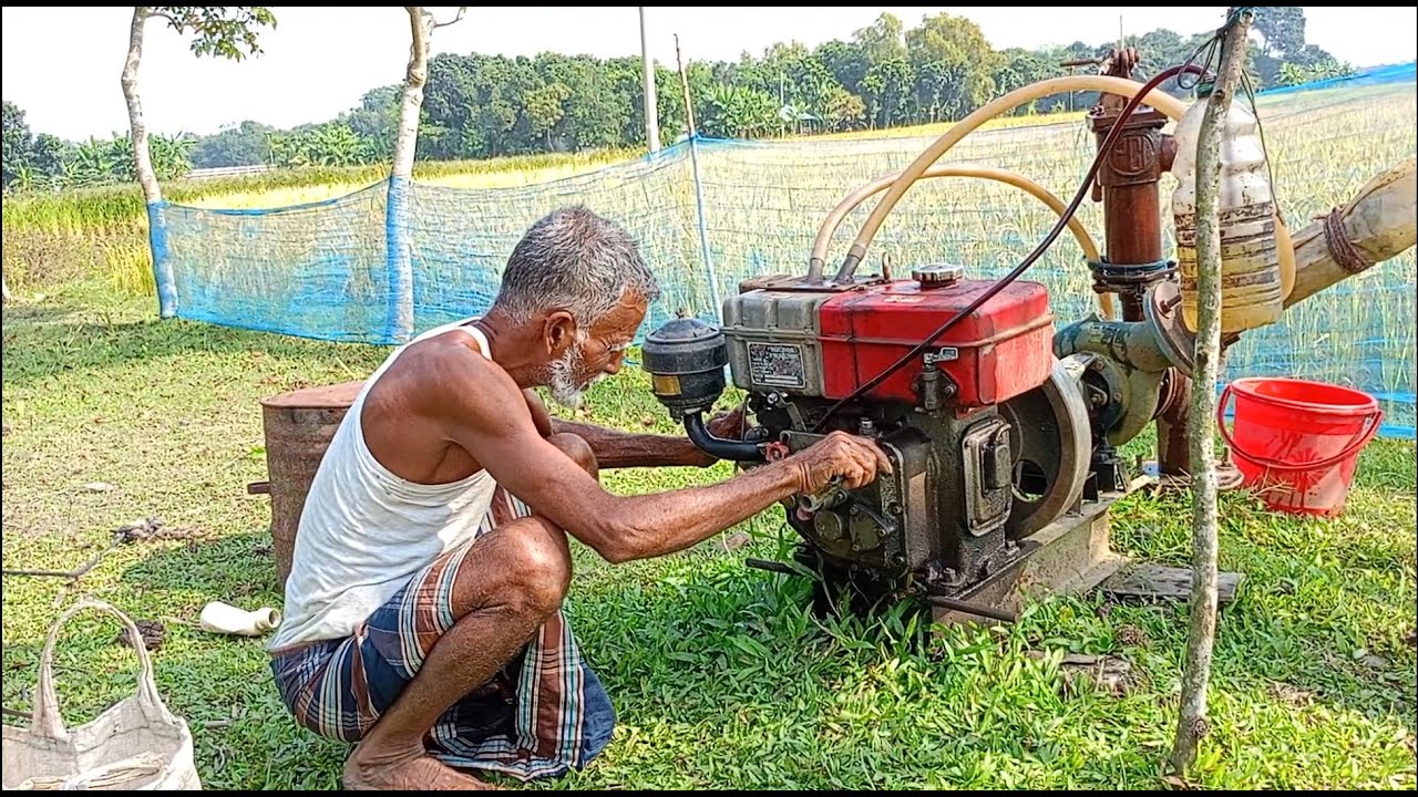 A farmers was watering his land by water pump. Water pump start process ...