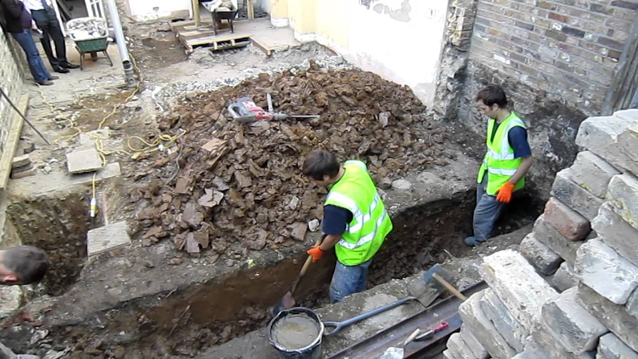 Workman forming strip footing for new rear extension - YouTube