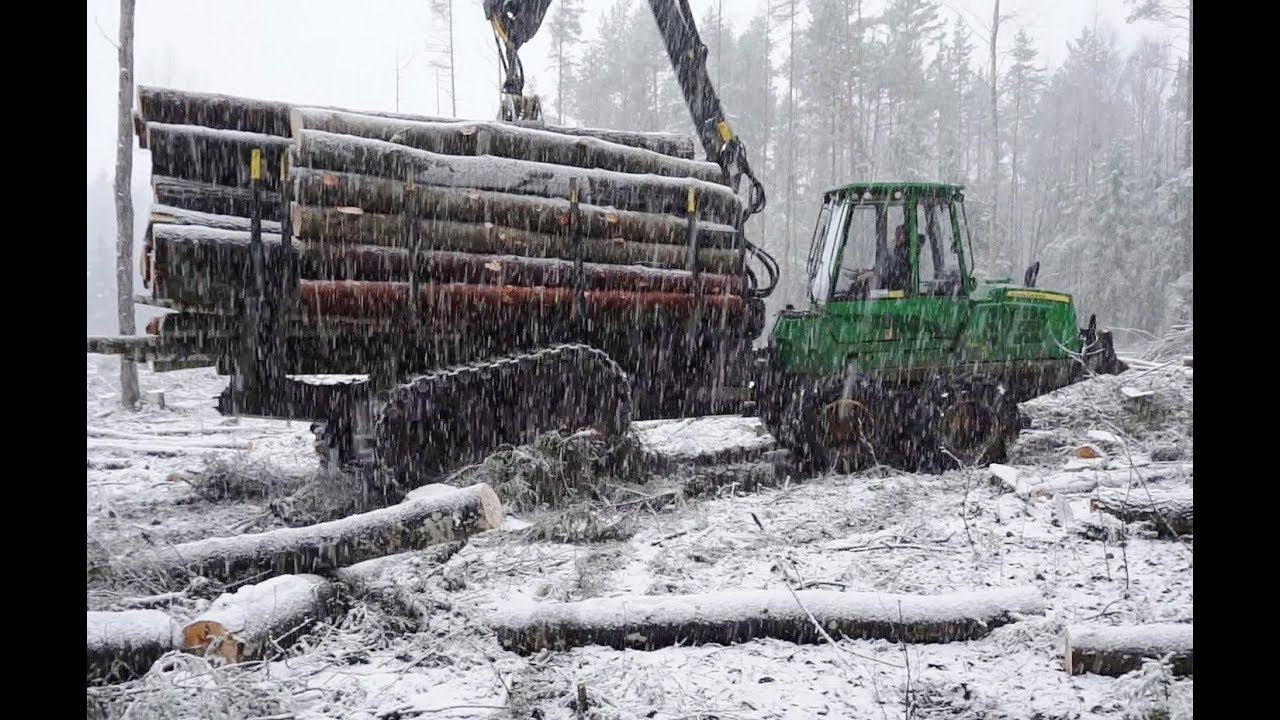 John Deere 1110E logging in snowy forest, big load, skilled operator ...
