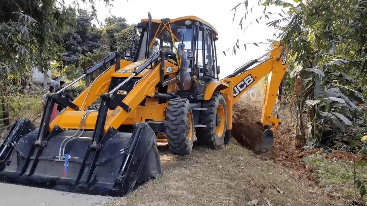 A new JCB machine is unloaded from a truck and begins digging a drain ...