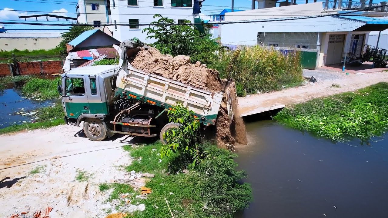 New Action Showing Dumping dirt into water flooding the Dump truck ...
