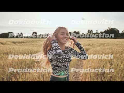 A beautiful blonde teen girl runs across a wheat field and turns around and smiles.