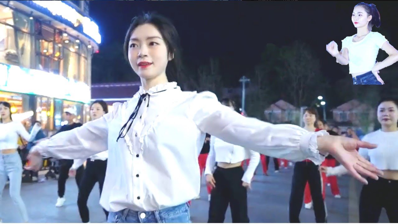 她的穿着白衬衣牛仔裤跳舞，她很迷人 She dances in a white shirt and jeans. She is ...