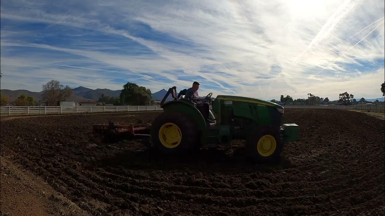 John Deere 5085M disking field for hay planting - YouTube