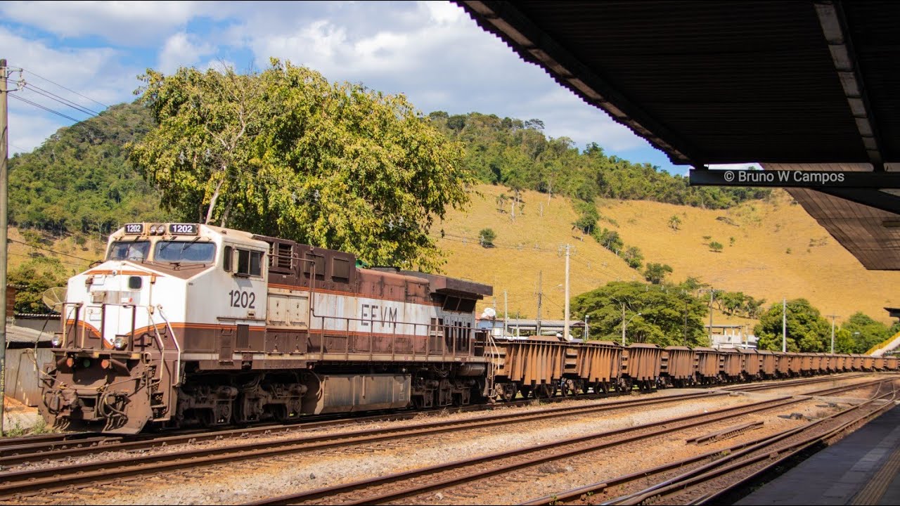 Locomotiva Dash-9 1202, única restante com a antiga pintura da EFVM passando em dois trens na ...