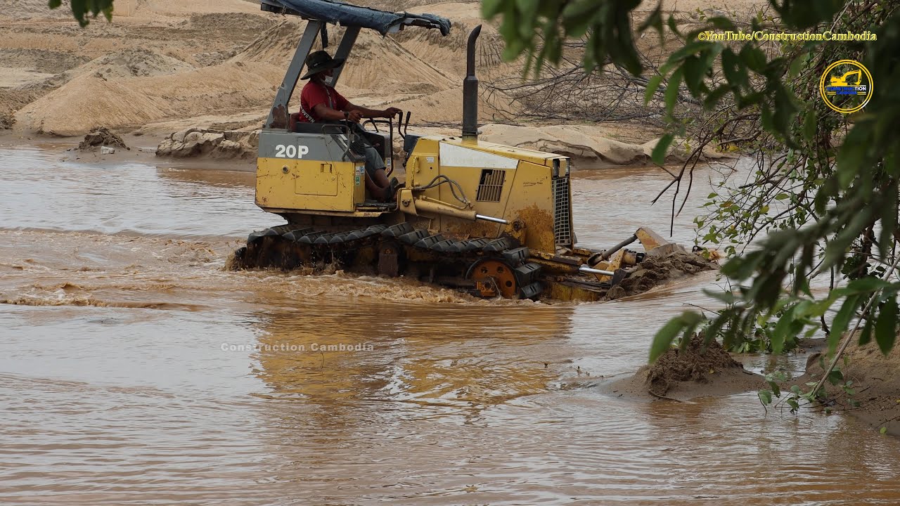 Komatsu d20p dozers pushing sand with 5 dump trucks unloading sand ...