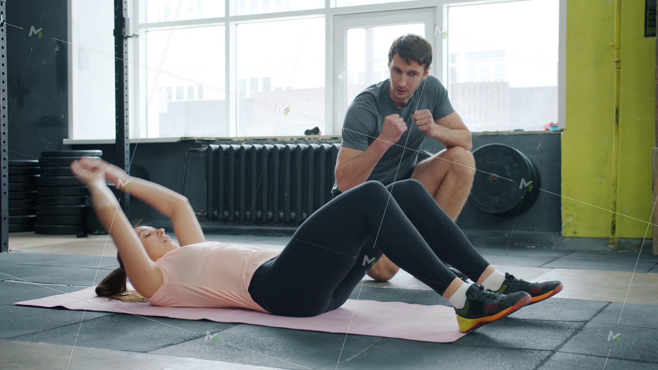 Slow motion of young woman doing sit-ups exercising in gym with ...