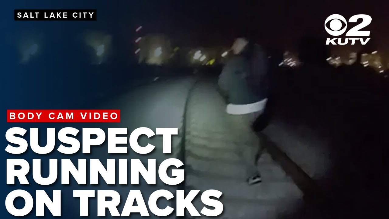 Body-worn camera shows suspect running on tracks, confronting officer ...