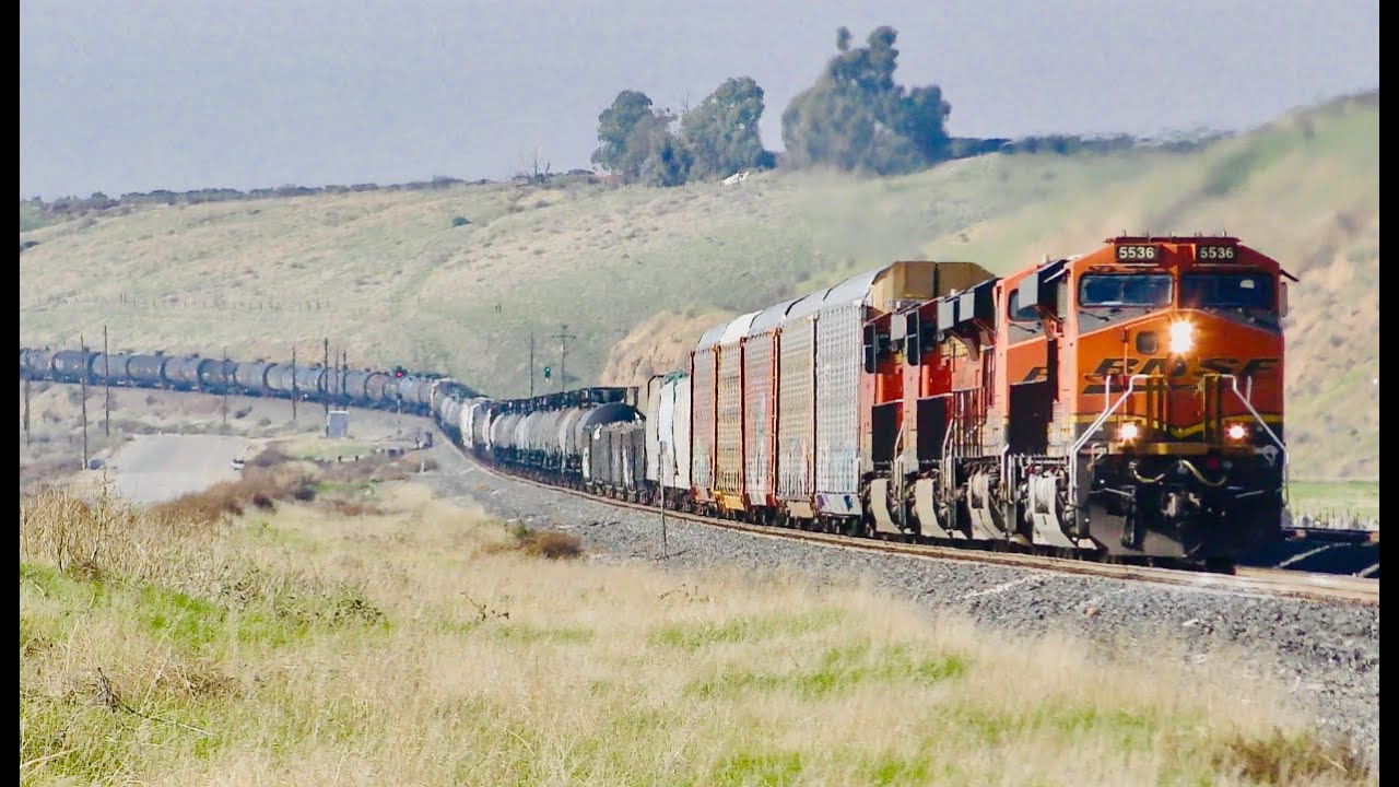 BNSF manifest rolls at Sand cut awaiting EB signal as a WB gets the green on adjacent track ...