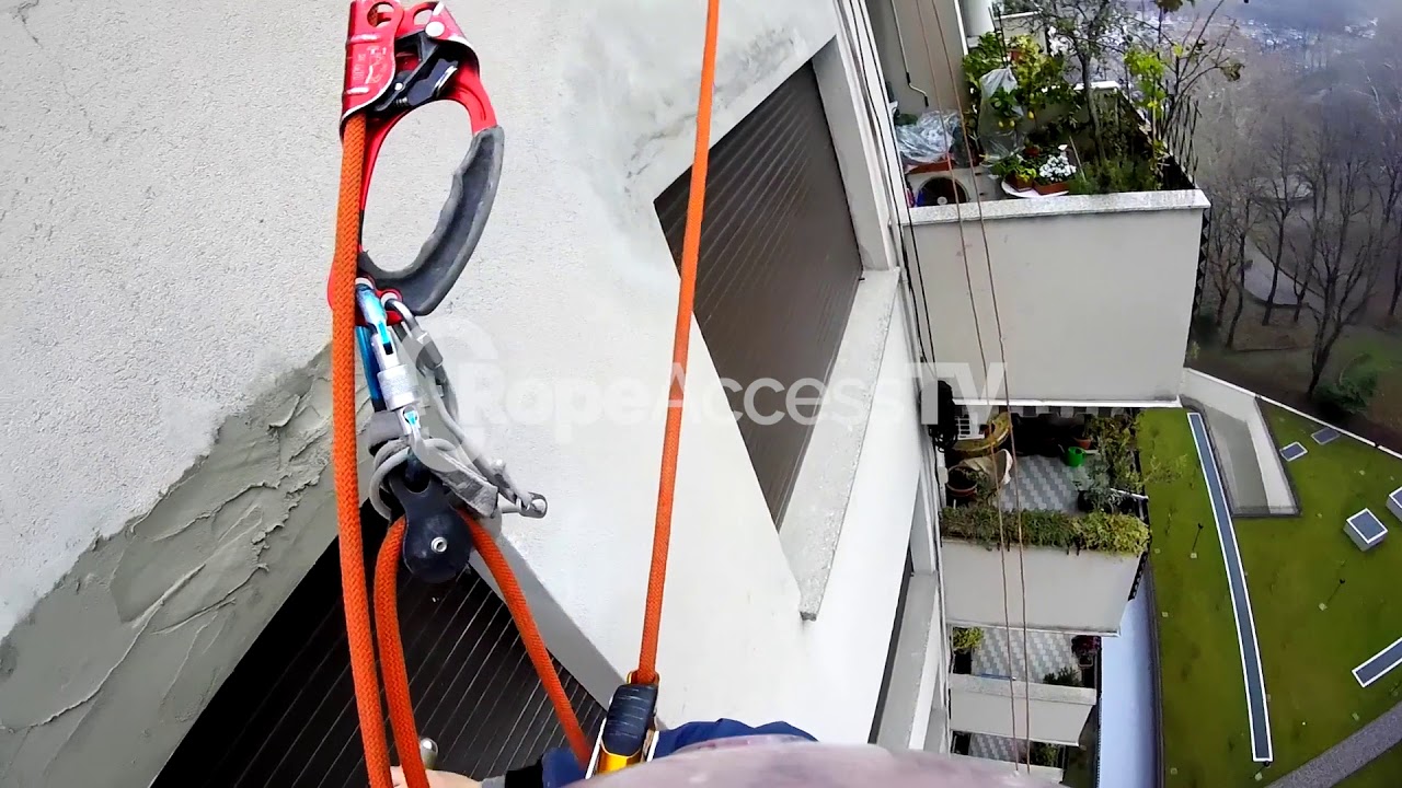 Abseiler does maintenance on exterior building facade - YouTube