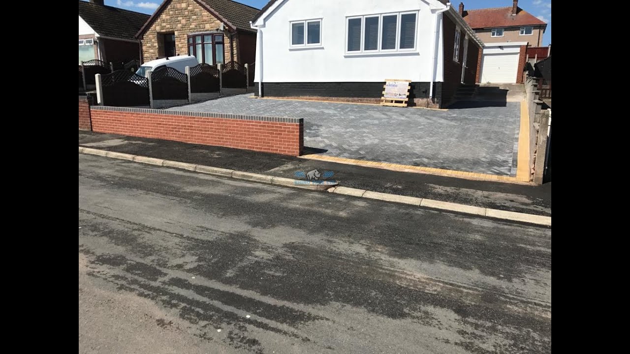 Charcoal Paved Driveway with Golden Edging and Brick Retaining Wall in ...