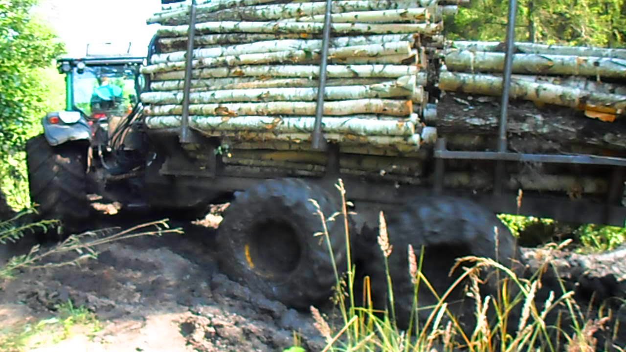 Valtra T131h forestry tractor with big homemade trailer in wet forest ...