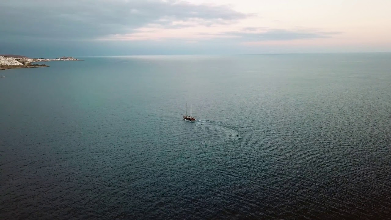 aerial view of small boat at open sea during the sunset horizontal view ...