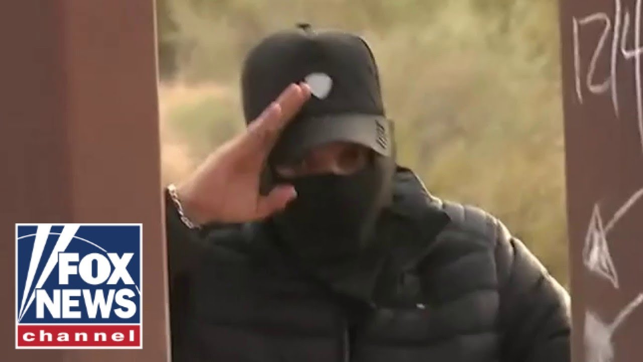 Human smuggler salutes camera at southern border - YouTube