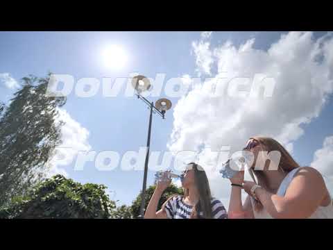 Young girls drink water from a bottle on a hot sunny day.