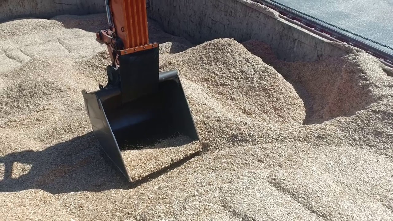 loading wood chips excavator - YouTube