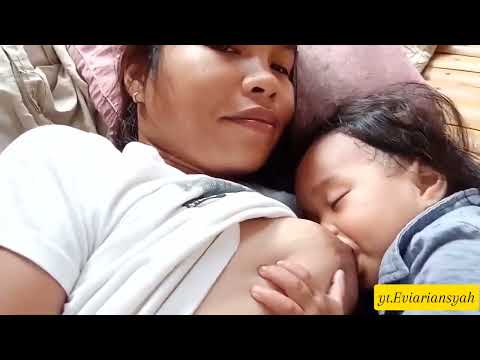 ibu menyusui bayi di kebun