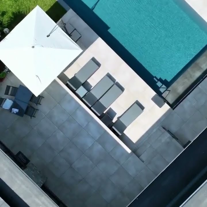 Un espace extérieur complet avec piscine, pool house et zones de ...