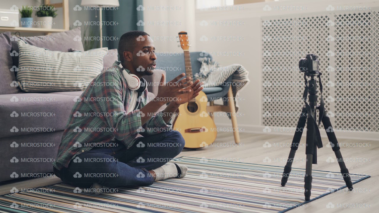 Young African American vlogger is recording video for internet blog ...