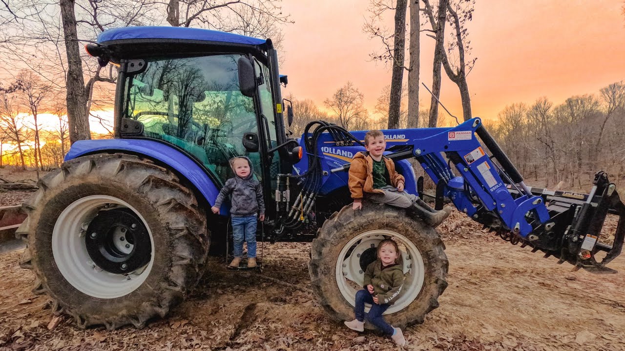 Real Tractor and kids working on the farm cutting up, knocking down ...