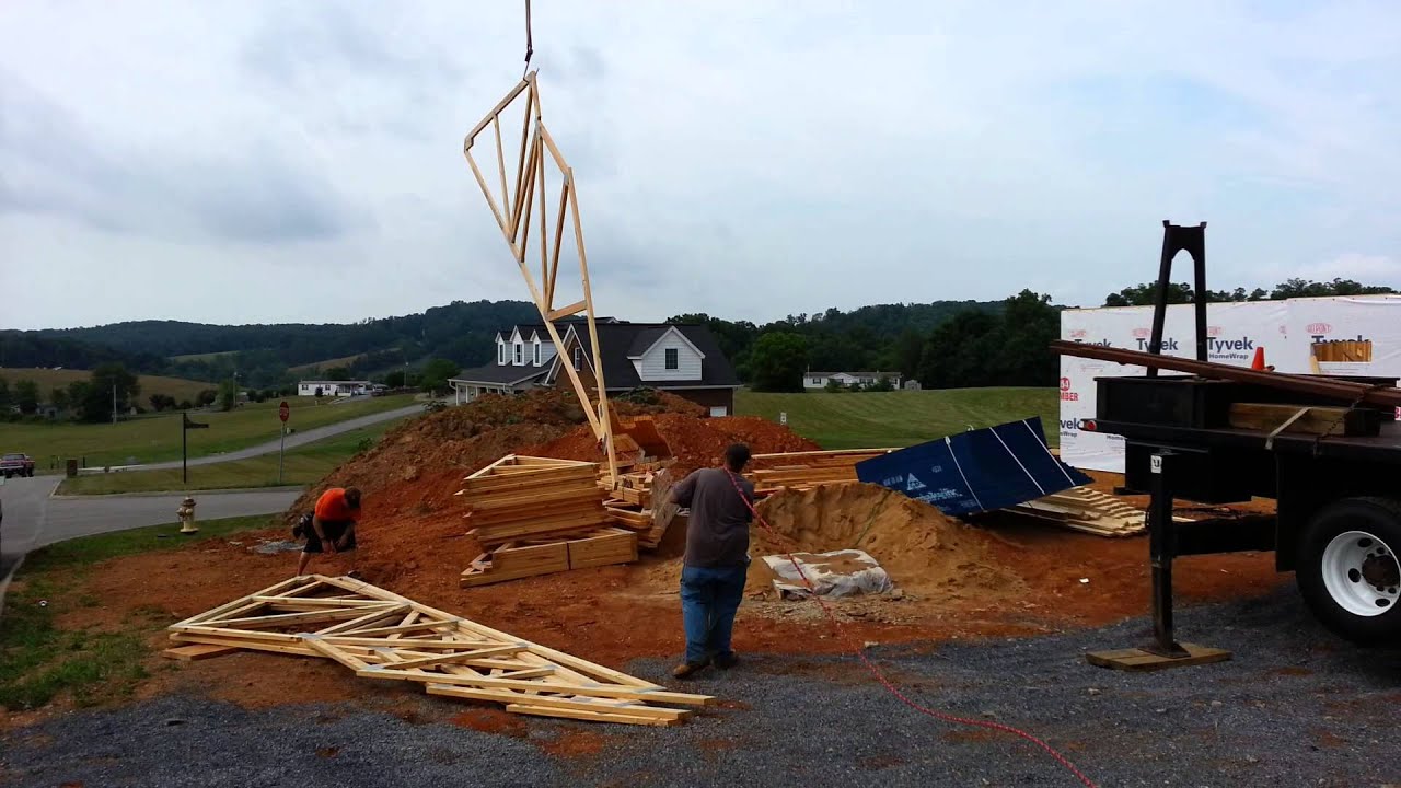 The framers using a boom truck to set the roof trusses. - YouTube
