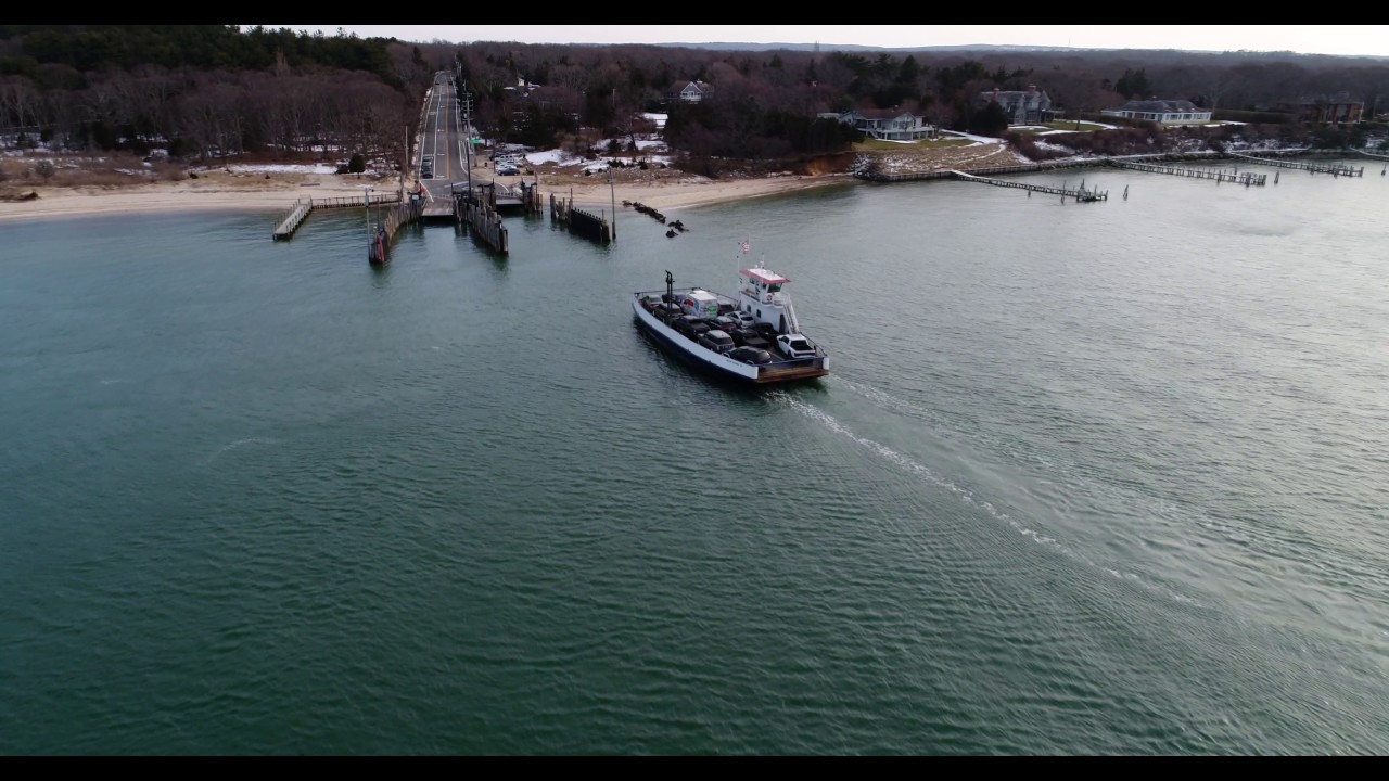 Aerial flight towards and over Shelter Island, New York, ferry headed ...