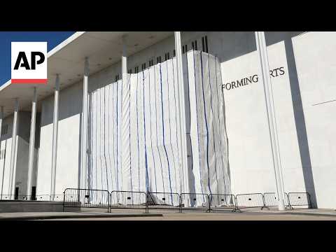Workers cover the Kennedy Center signage before removing Trump's name