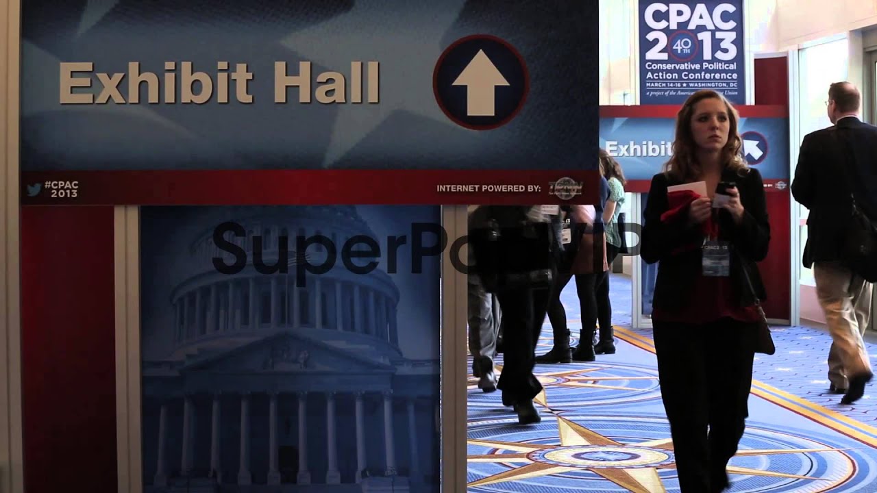 Attendees pass by CPAC signs during the first day of CPAC... - YouTube
