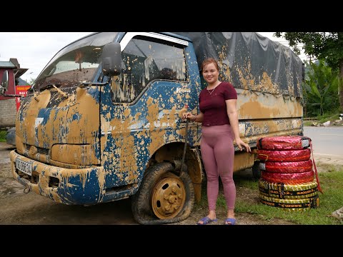 The girl repaired and replaced all the broken truck tires in the middle of the road.