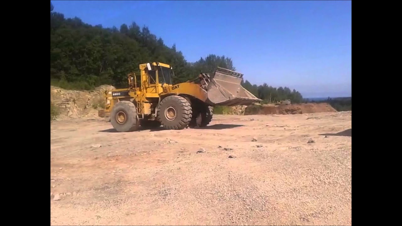 Old CAT loader loading dump truck with big rocks - YouTube