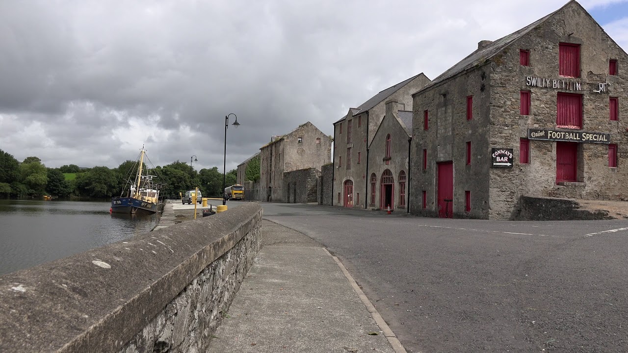 Old stone warehouses stand in a row along a street by the River Lennon ...
