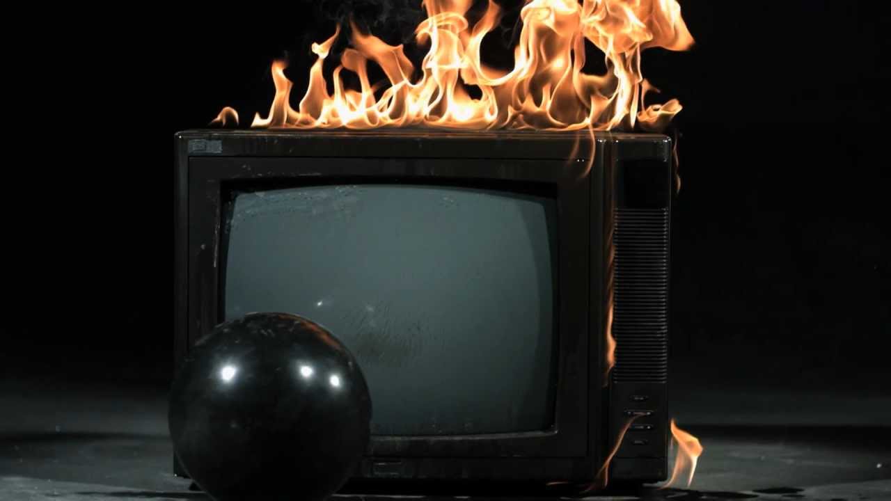 Smashing TV in Slow Motion a Burning Television hit by Black Ten Pin ...