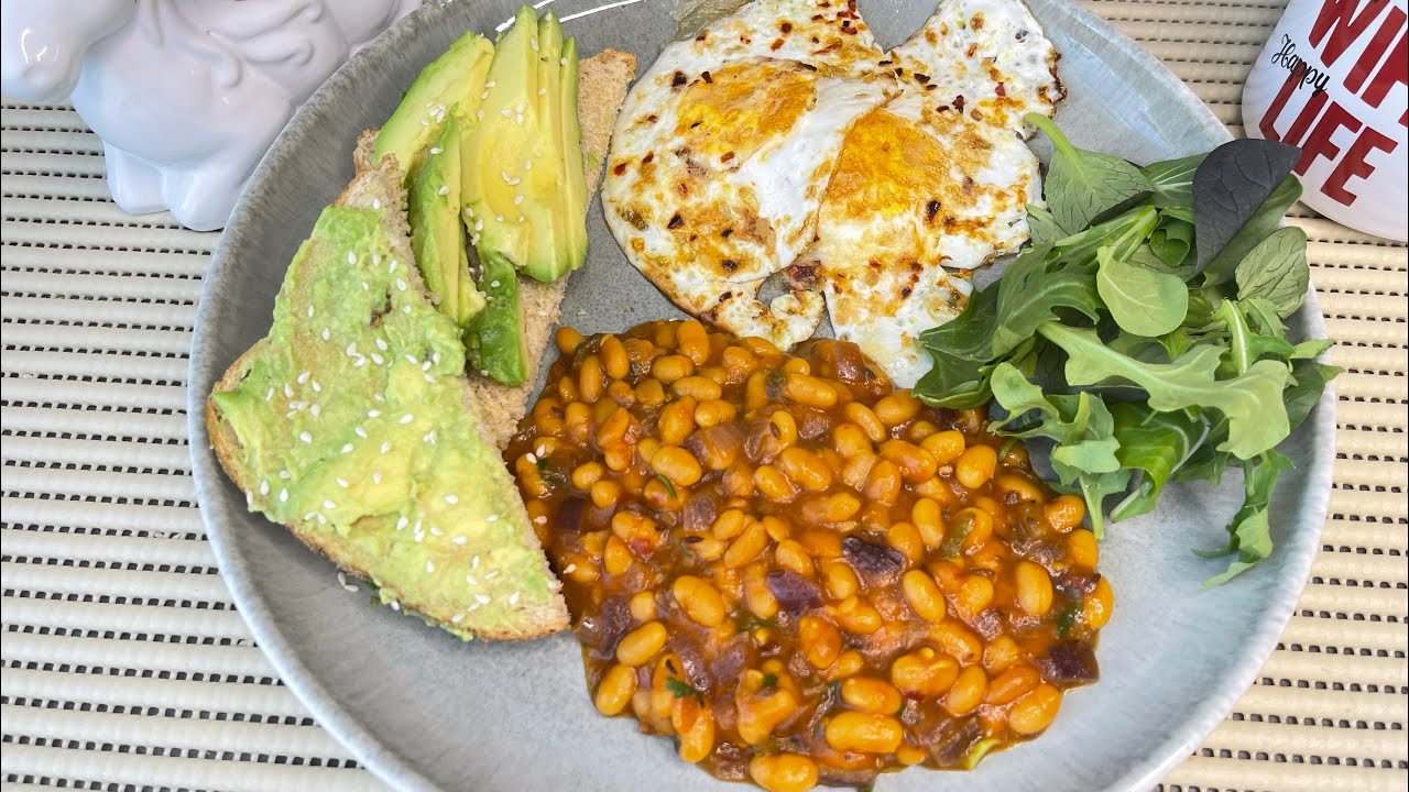 English breakfast with Red beans, toasts with avocado, fried eggs and ...