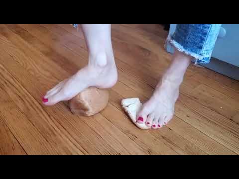 Home baked loaf of bread crushing bare Foot.