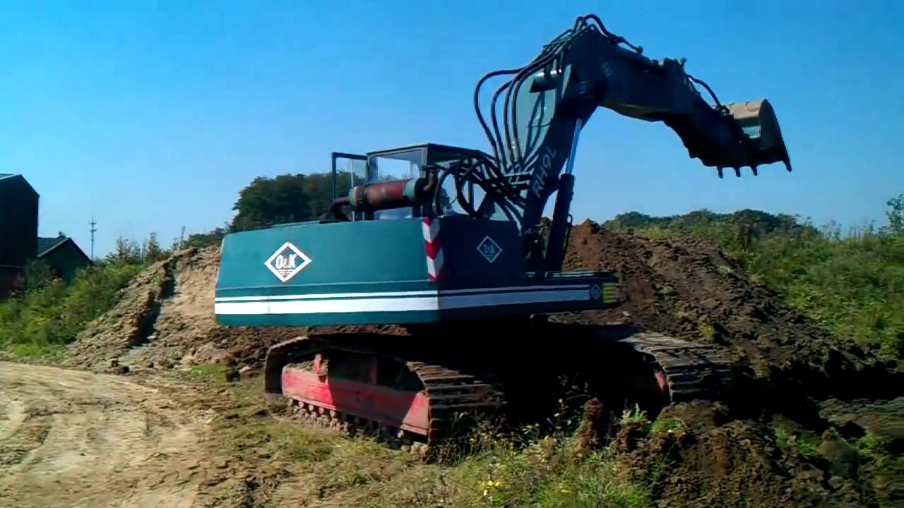 O&K Excavator digging some ground - YouTube