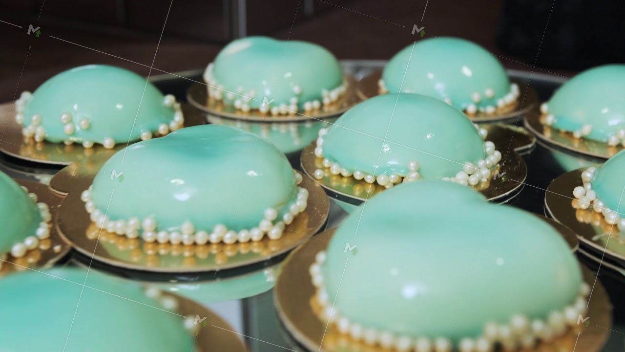 Wedding turquoise sweets and cookies on a mirrored tray. Camera flying ...