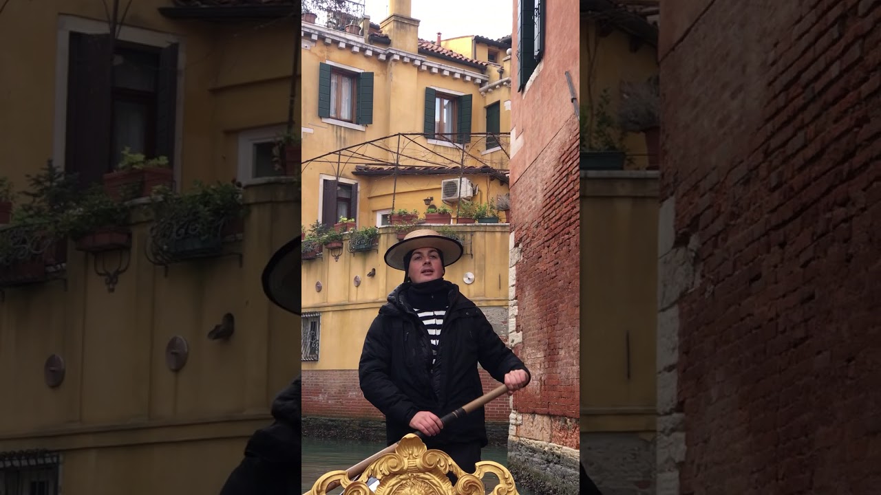Gondolier singing an Italian song during a Gondola ride in Venice ...