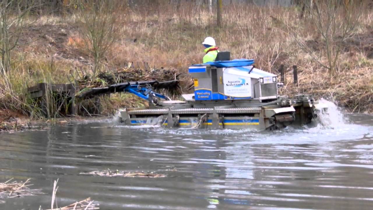 Truxor Excavator and Clearing Rake cleaning the lake at the Earth ...