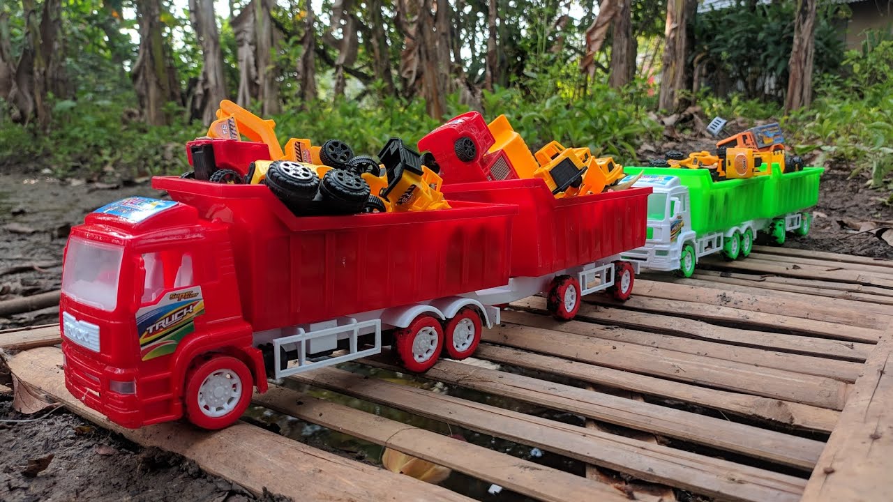 Truk gandeng panjang penuh muatan mobil mobilan, excavator, hewan ...