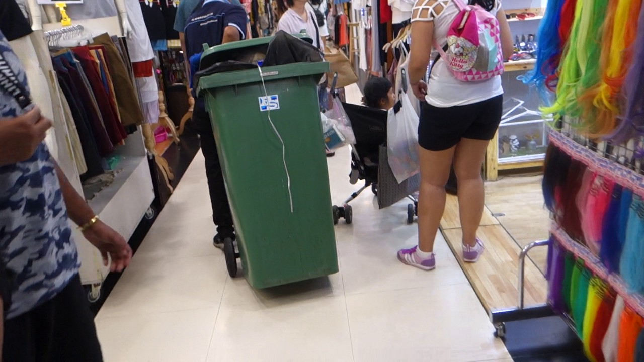 Man wheeling a garbage bin in a shopping mall in Prathunam, Bangkok ...