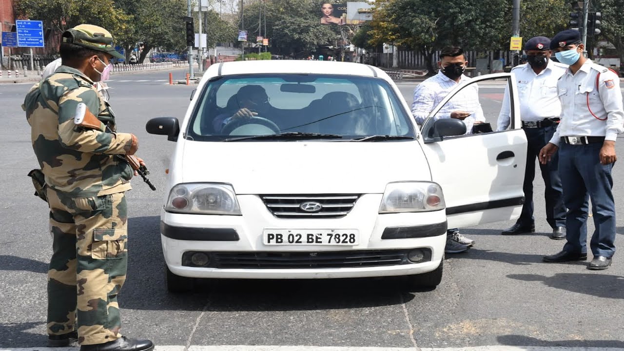 New Delhi: Police personnel checks ID cards of commuters during second ...