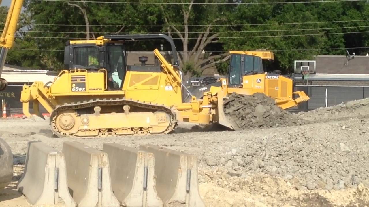 Komatsu D65wx bulldozer and tracked dumptruck building a stockpile ...